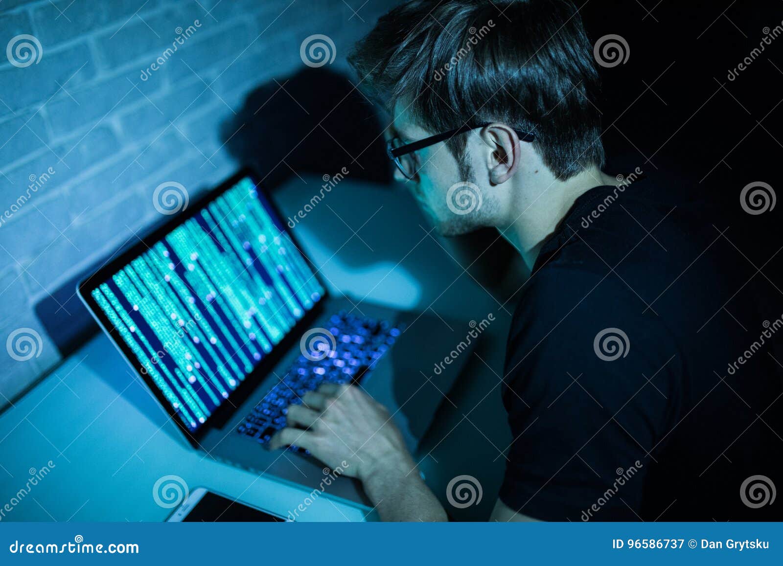 Young Man Hacker Working on Laptop Attack the Network Software in Night ...