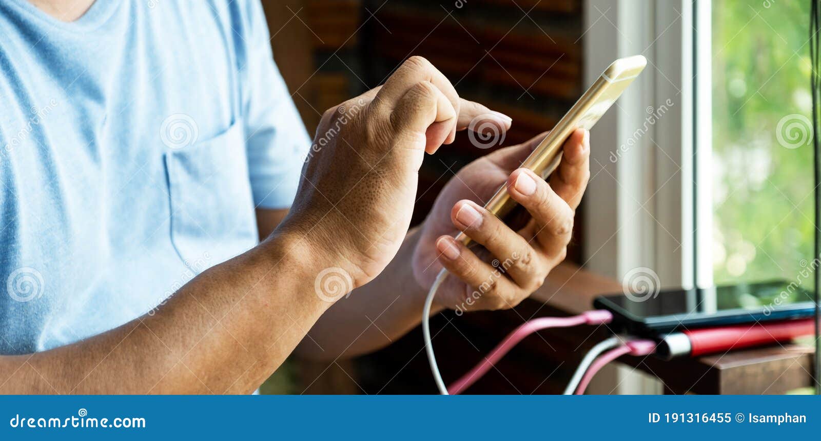 Young Man Hands Holding and Playing Smartphone while Charging the ...