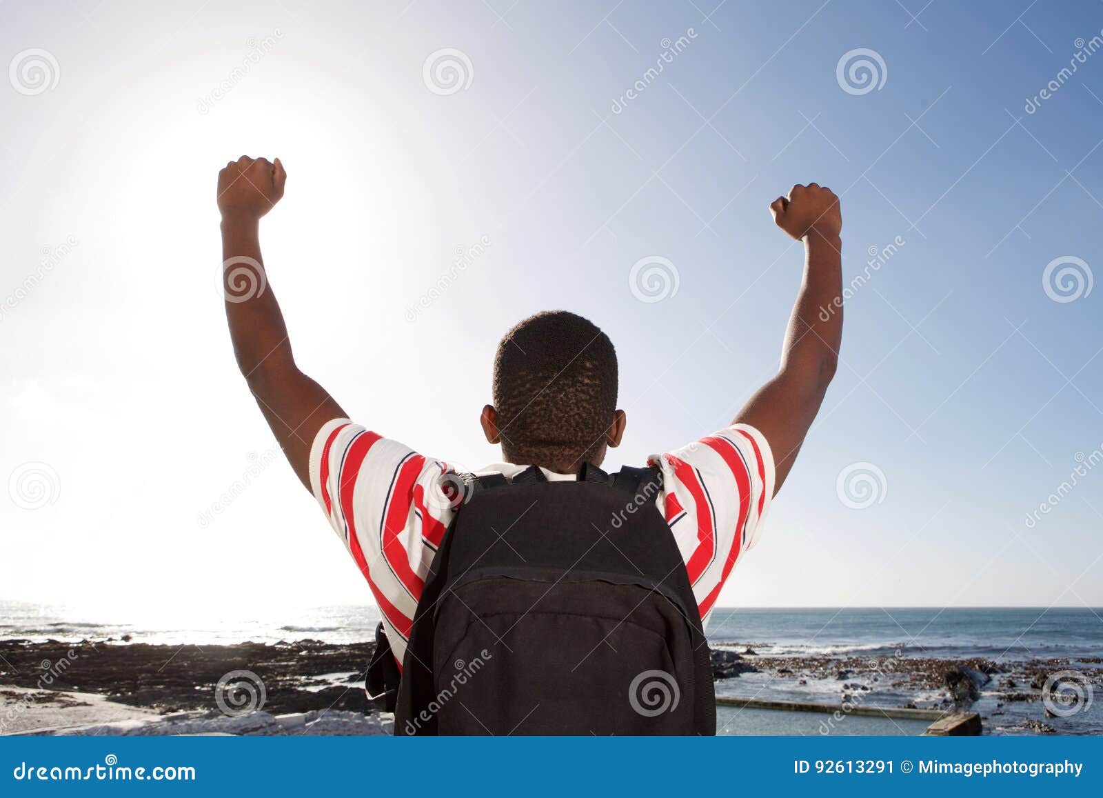 Young Man with Hands Raised Overlooking Beach Stock Image - Image of ...