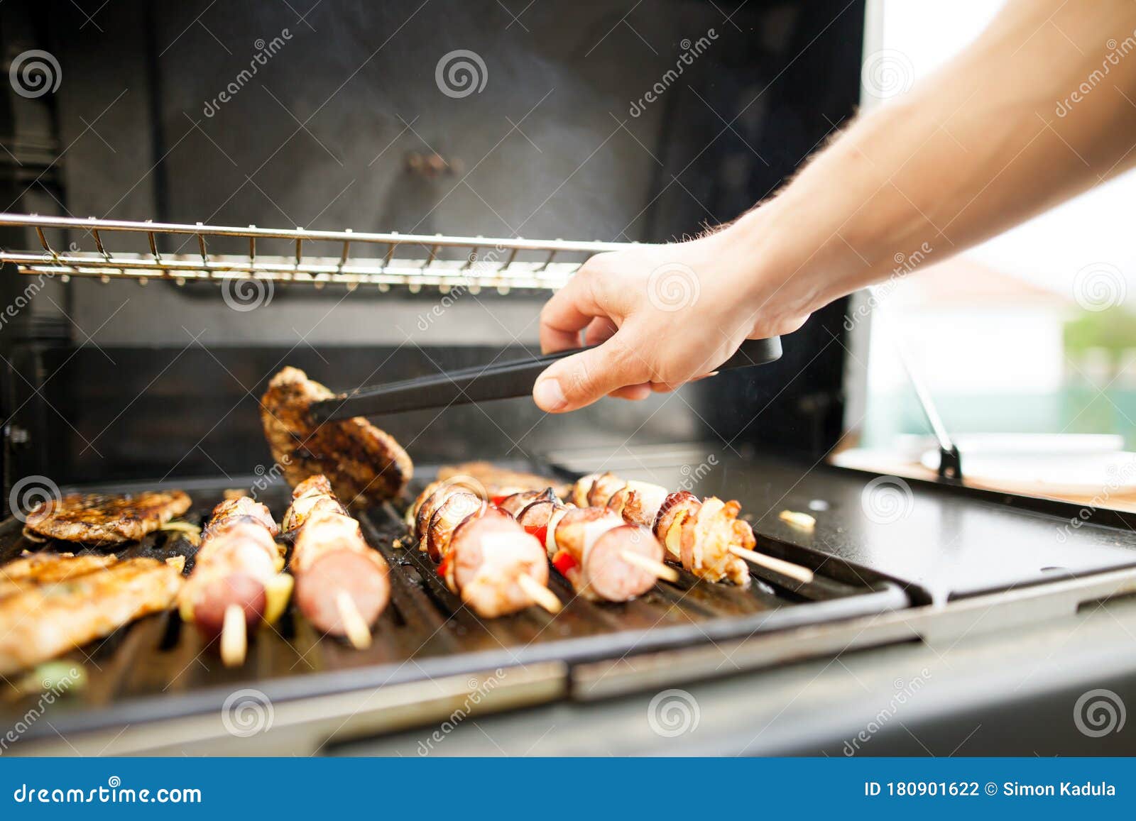 Young Man Hands Turning the Meat by Fork on the Gas Grill, BBQ Concept ...