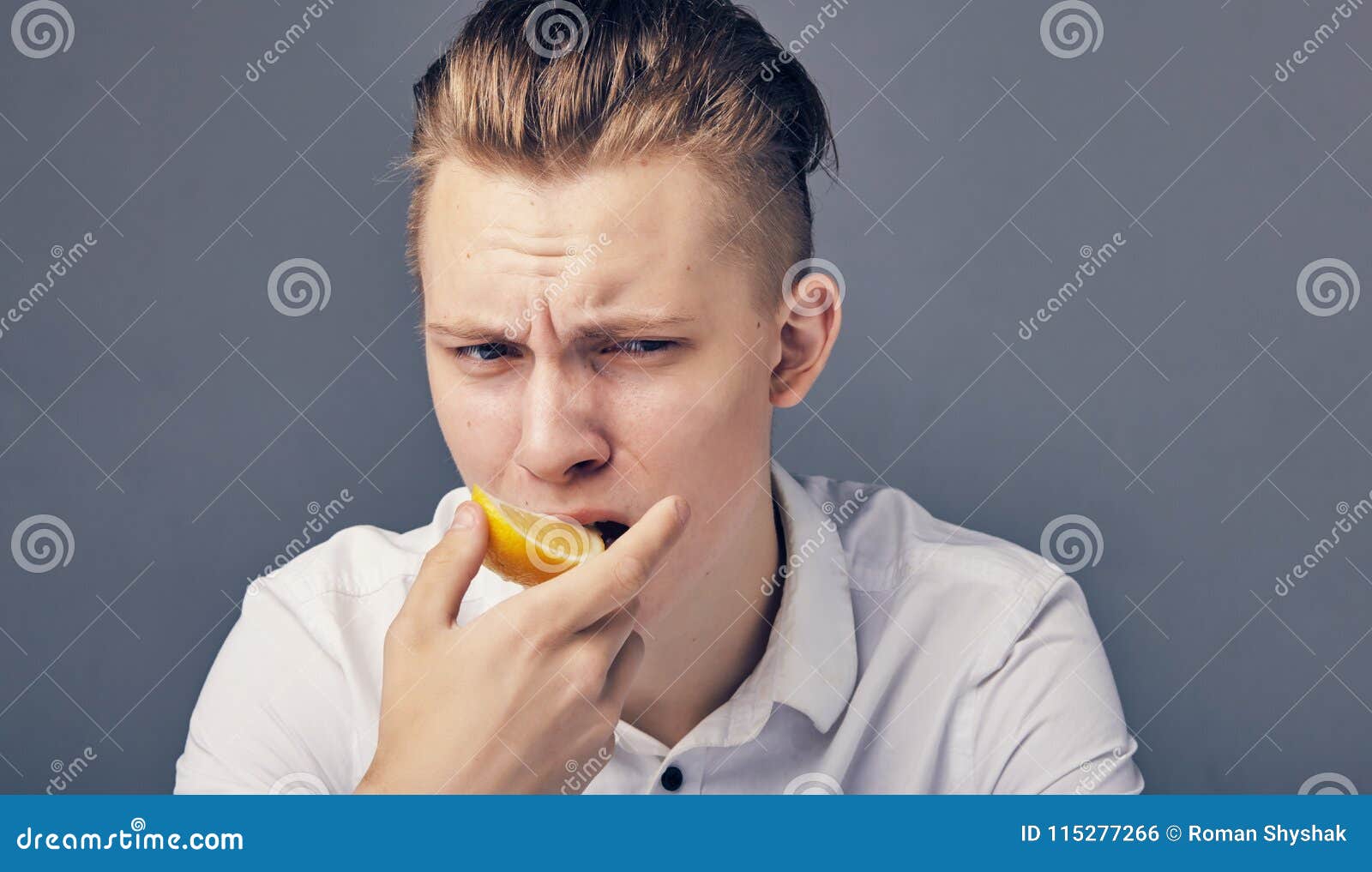 Young man tasting lemon. stock photo. Image of mature - 115277266