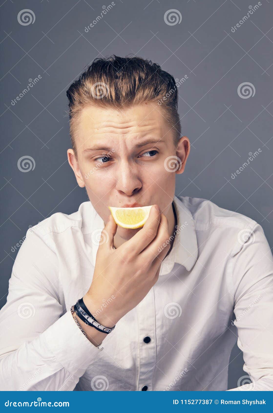 Young man tasting lemon. stock image. Image of juicy - 115277387