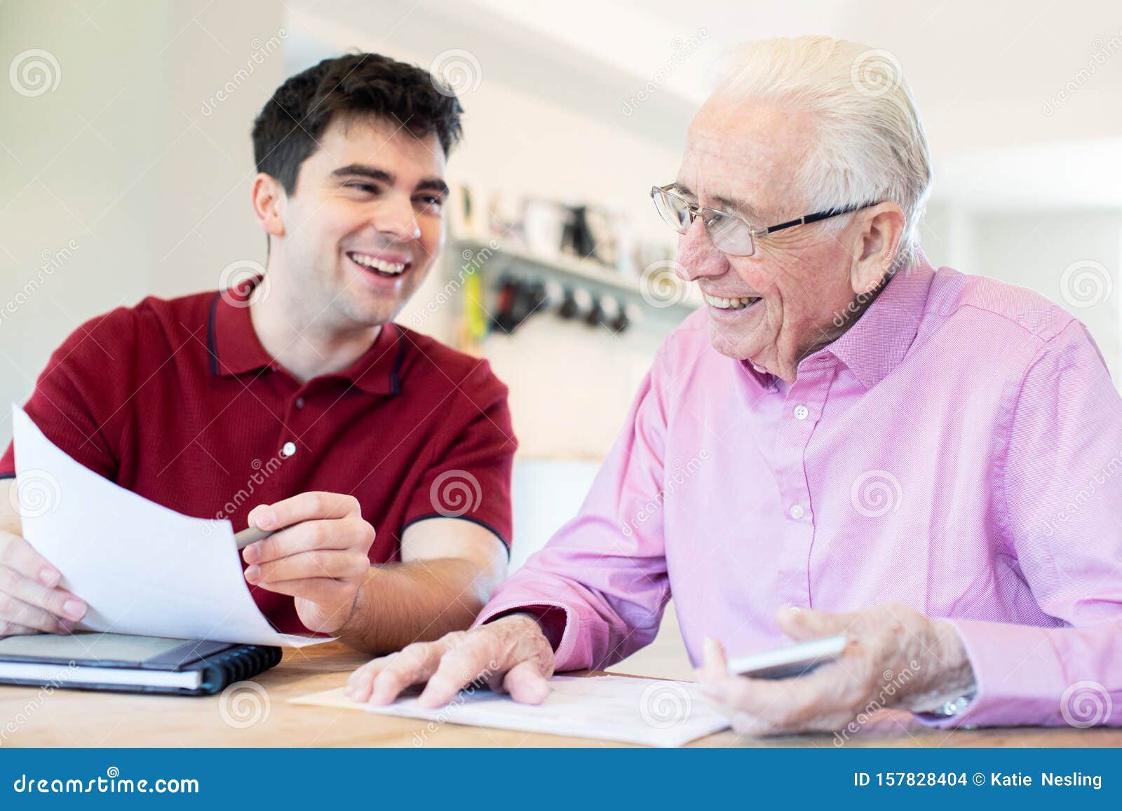 Young Man Helping Senior Neighbor with Paperwork at Home Stock Photo ...