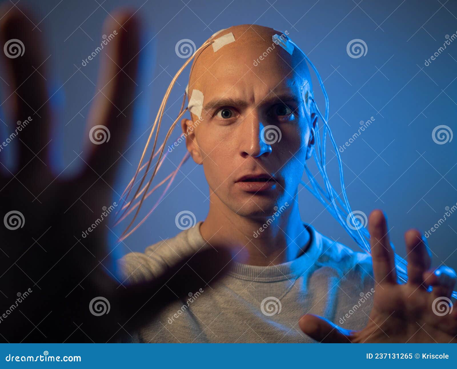 A Young Man with His Head Entangled in Wires, Pulls His Hands Forward ...
