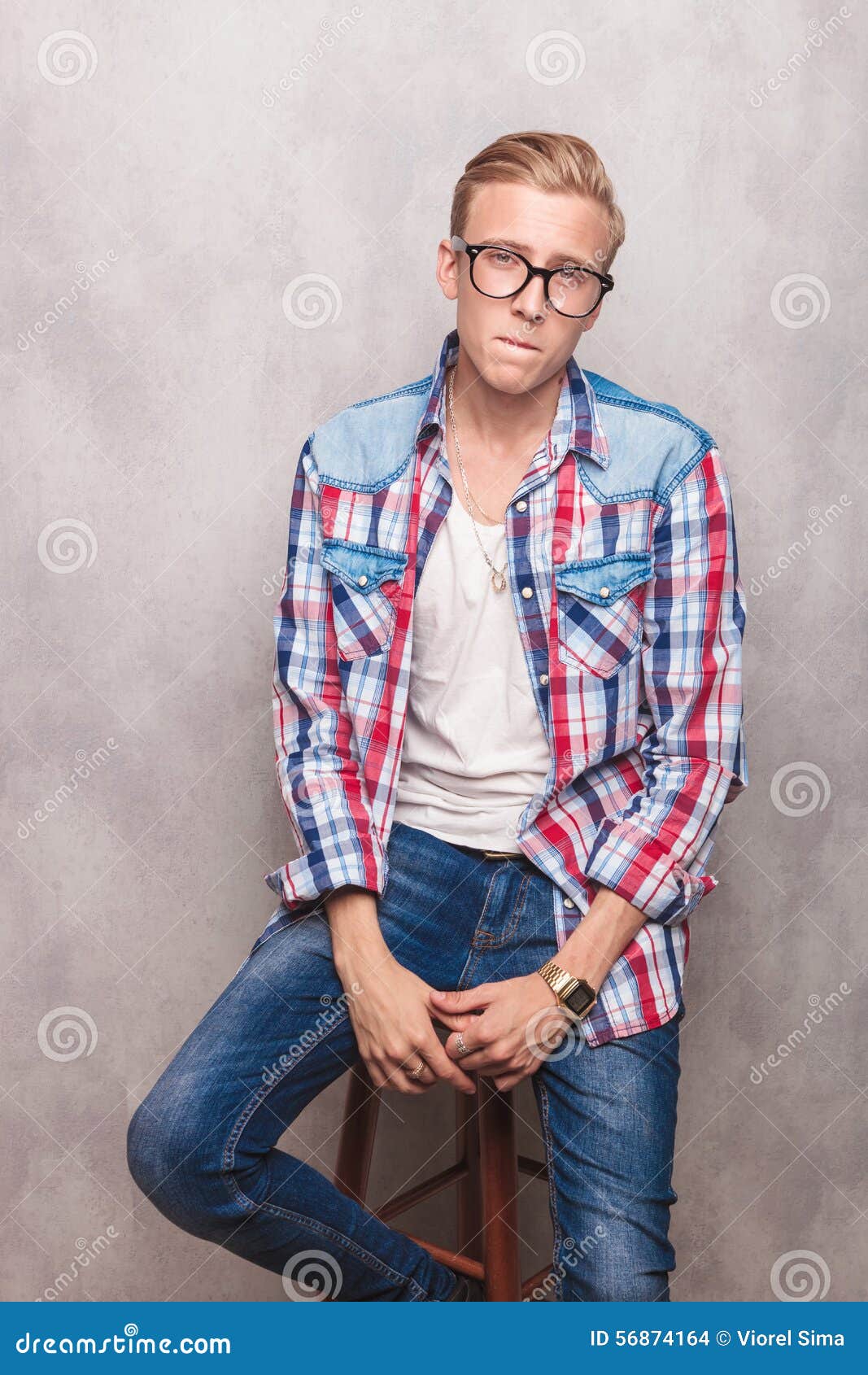 Young Man Hoding His Hands Together Stock Photo - Image of seated, grey ...