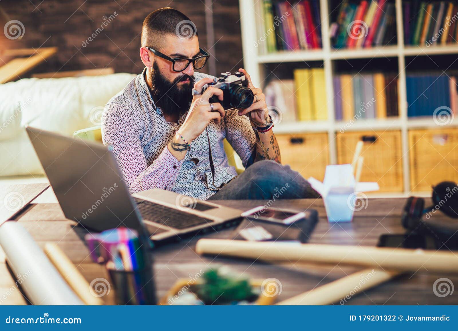 Man Holding Camera and Sitting by Table with Computer at Home Office ...