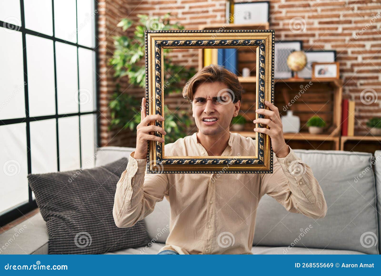 Young Man Holding Empty Frame Clueless and Confused Expression Stock ...