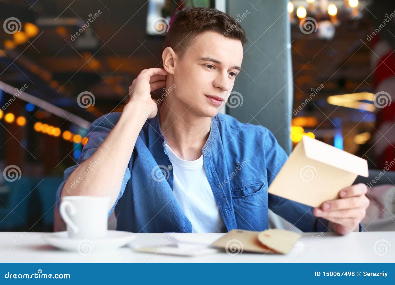 Young Man Holding Envelope at Table in Cafe. Mail Delivery Stock Photo ...