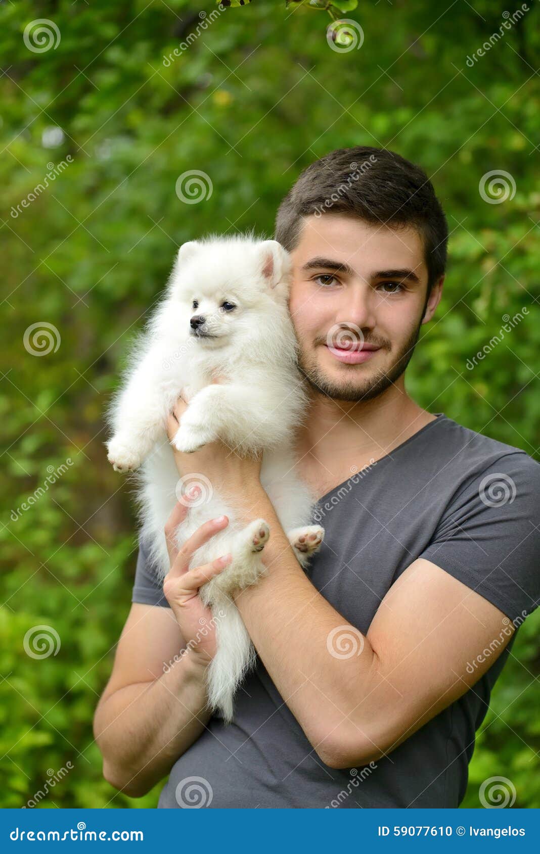 Young Man Holding German Spitz Puppy Stock Photo - Image of canine ...