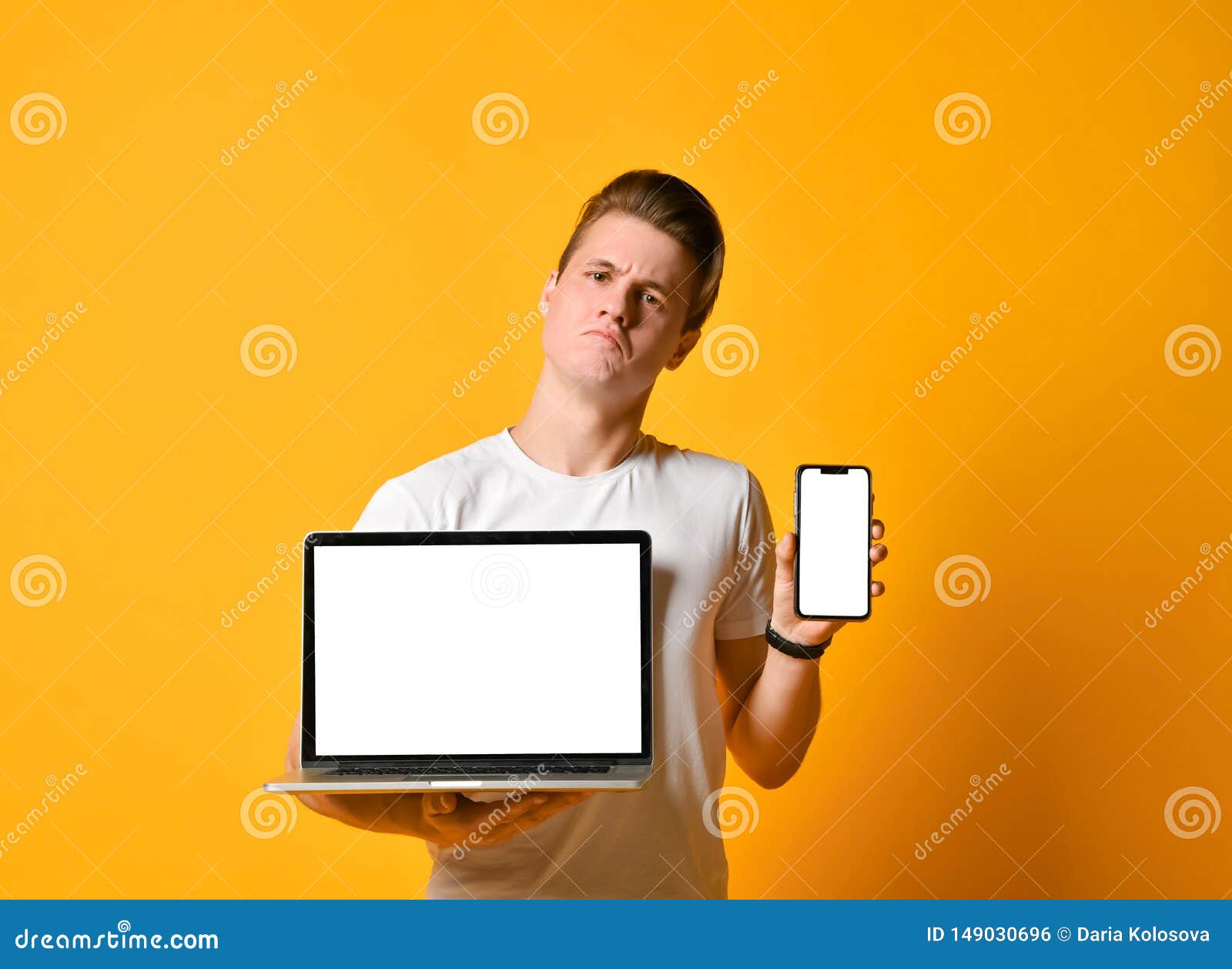 Young Man Holding a Laptop Computer and Mobile Smart Phone, Standing ...