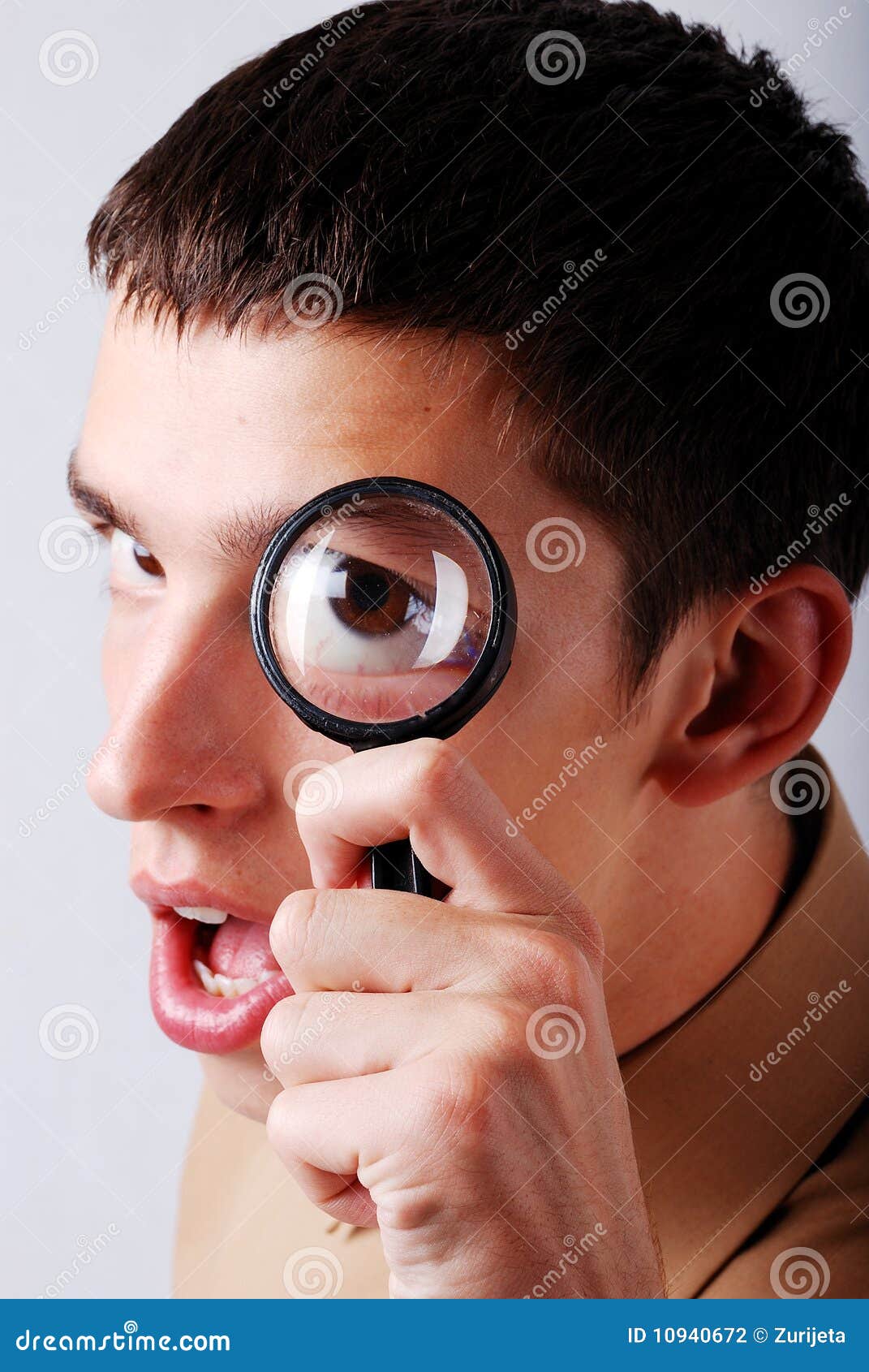 Young Man Holding a Magnifier on His Eye Stock Photo - Image of close ...