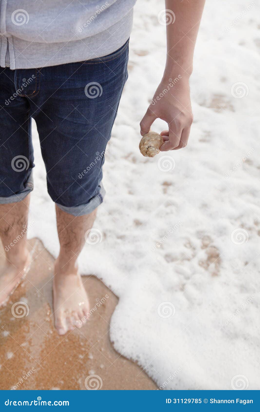 Young Man Holding a Seashell, High Angle View Stock Image - Image of ...