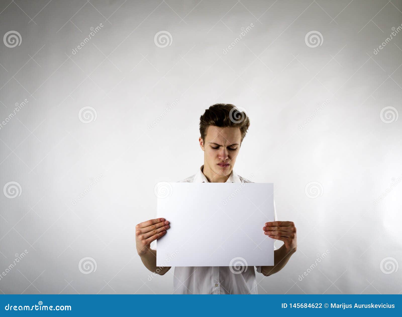Young Man Holding White Paper in His Hands. Unhappy. Stock Photo ...