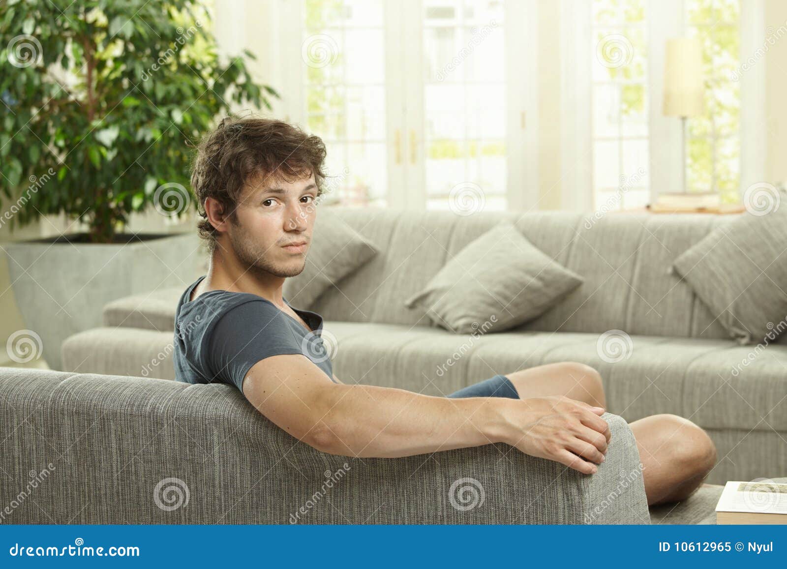 Young man at home stock image. Image of furniture, caucasian - 10612965