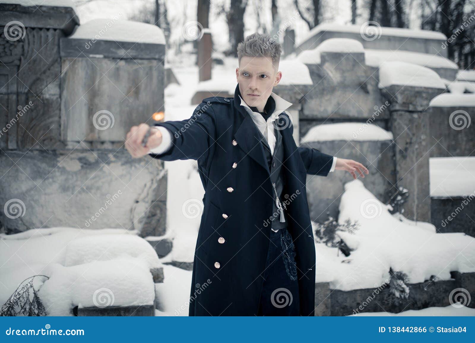 Young Man in Image of Black Magician Makes a Spell Using Magic Wand ...