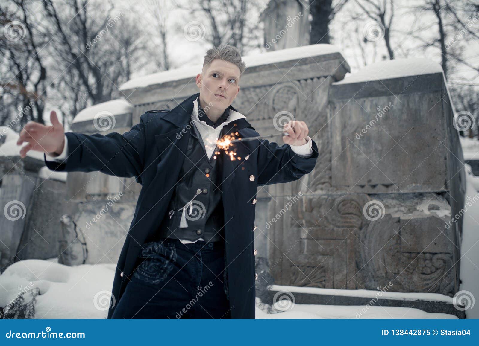 Young Man in Image of Black Magician Makes a Spell Using Magic Wand ...
