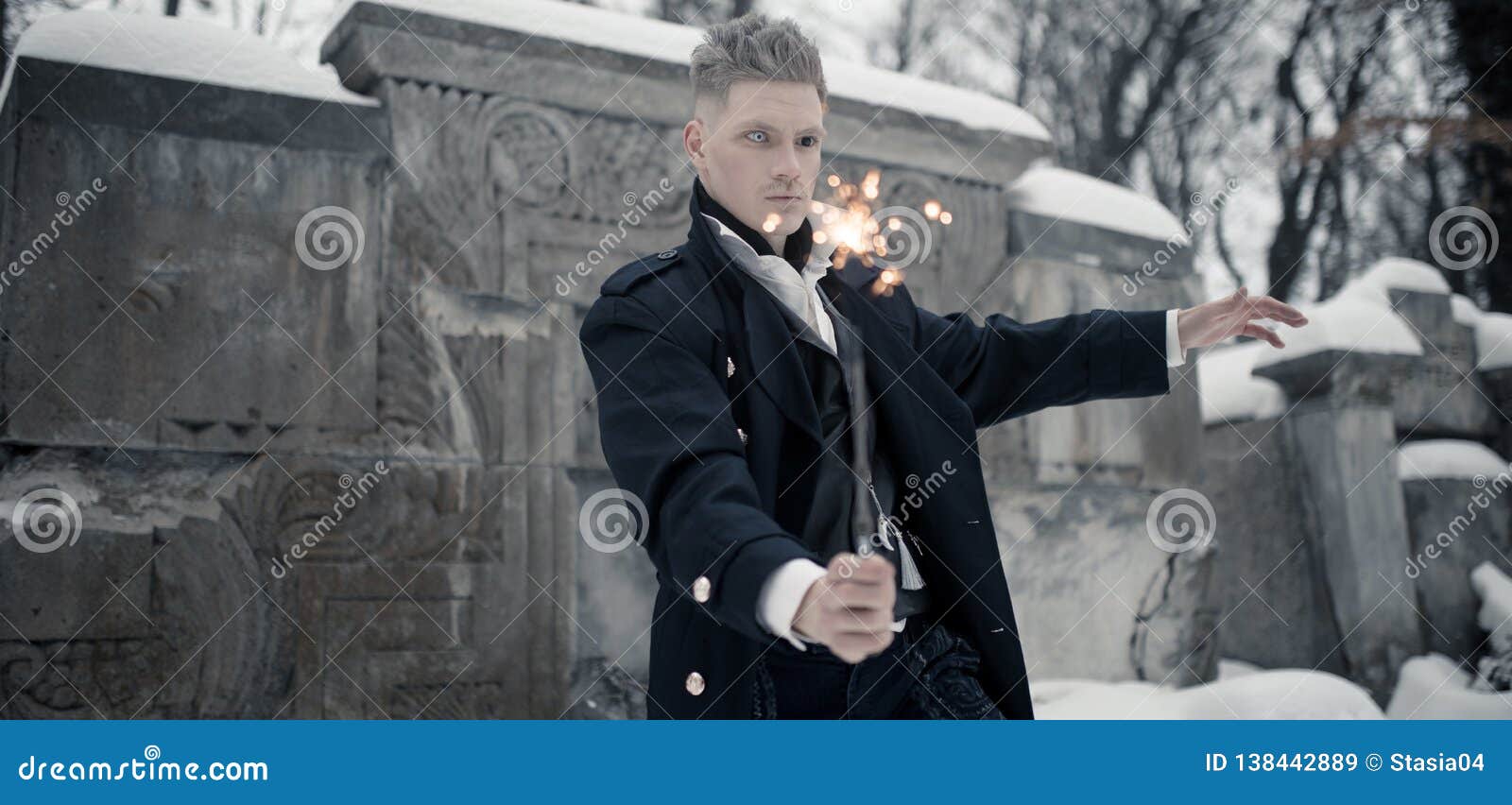 Young Man in Image of Black Magician Makes a Spell Using Magic Wand ...