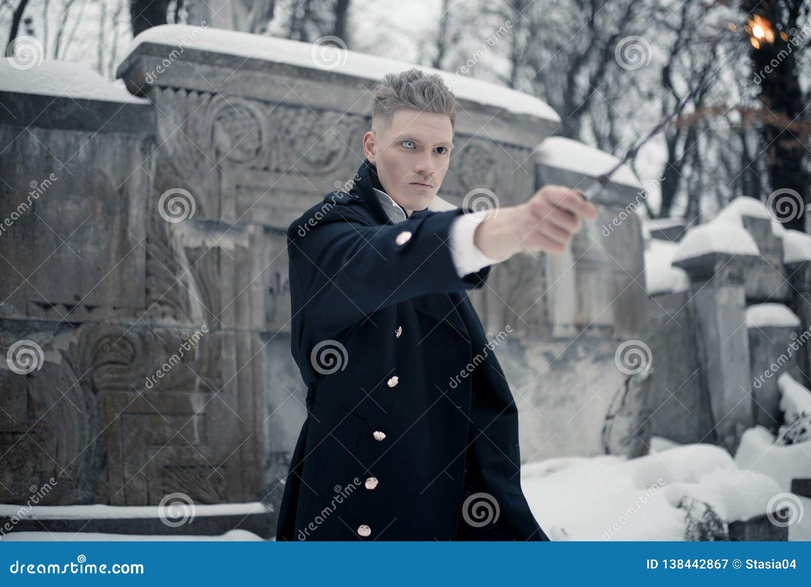 Young Man in Image of Black Magician Makes a Spell Using Magic Wand ...