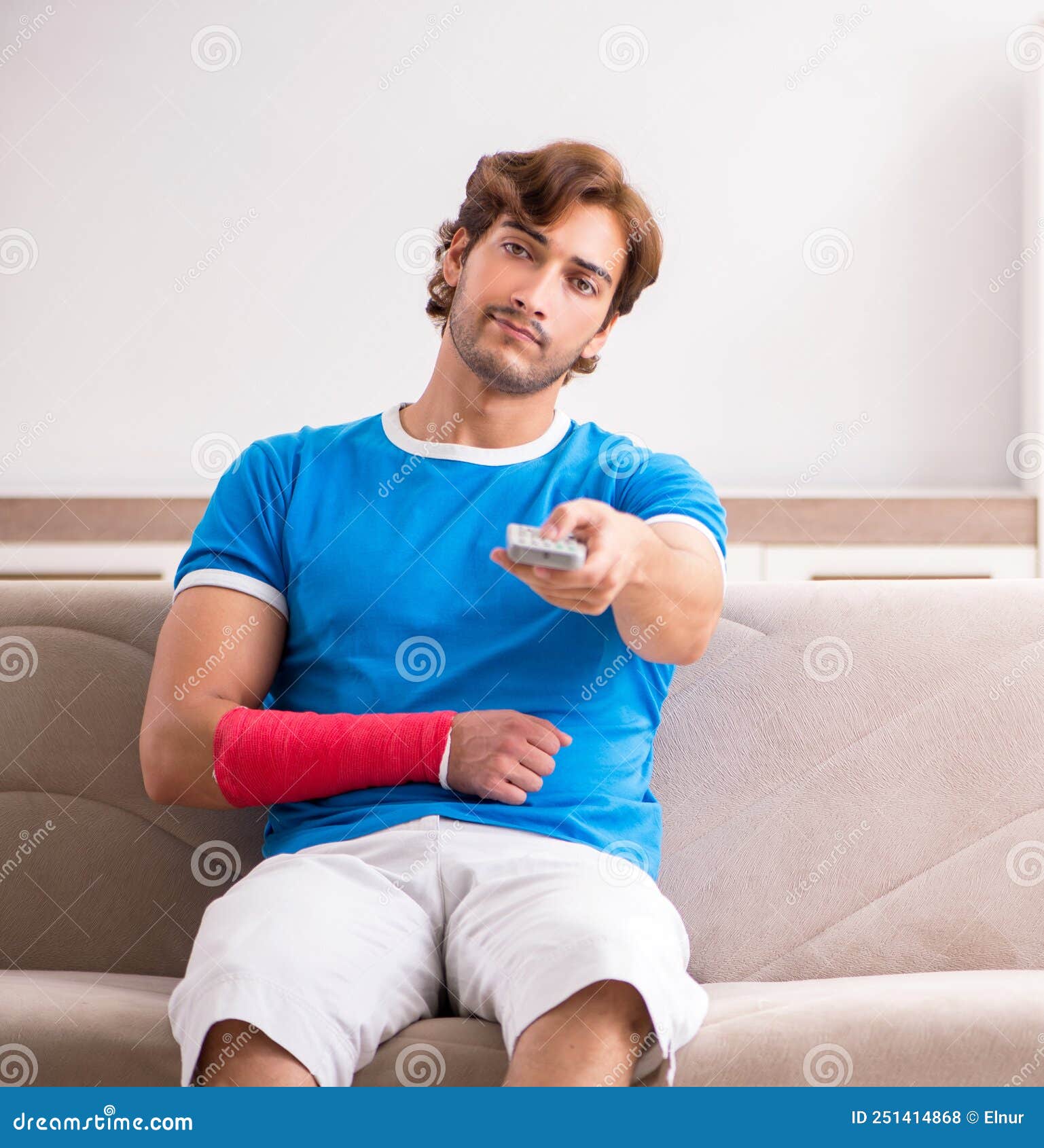 Young Man with Injured Arm Sitting on the Sofa Stock Photo - Image of ...