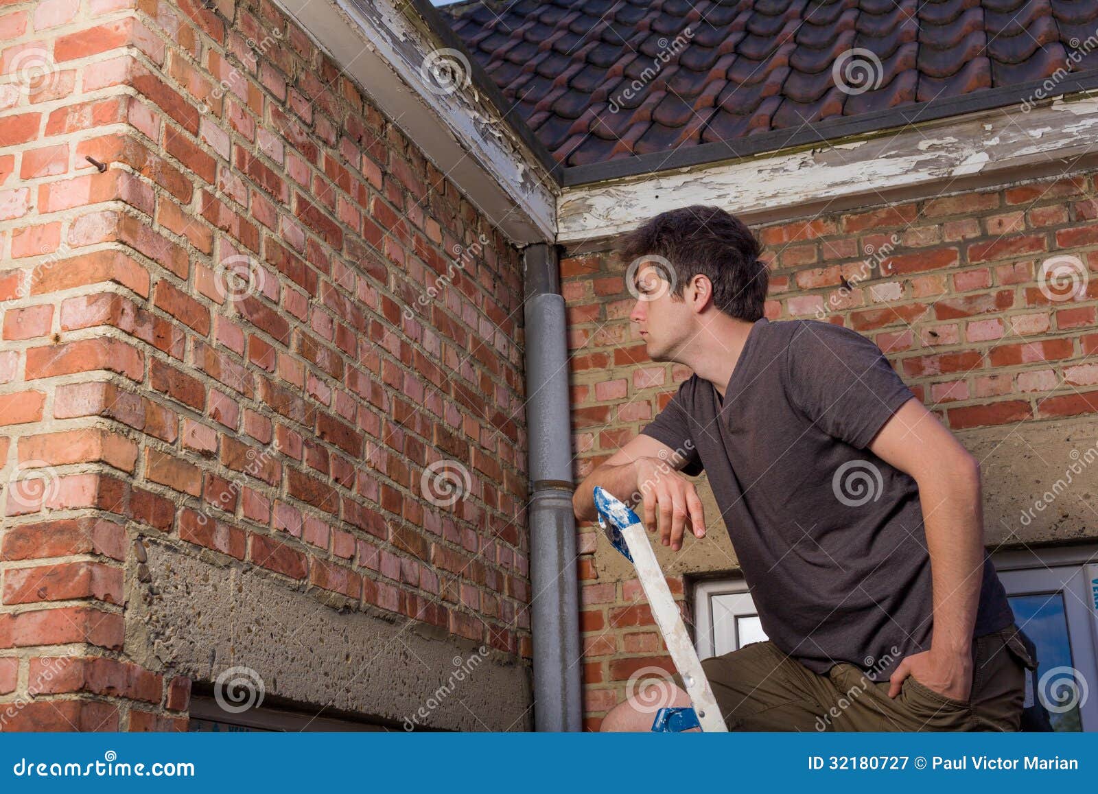 Young Man Inspecting the Wall of an Old House Stock Image - Image of ...