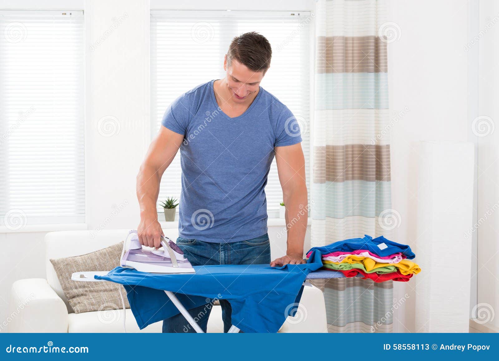 Young Man Ironing Clothes stock image. Image of holding - 58558113