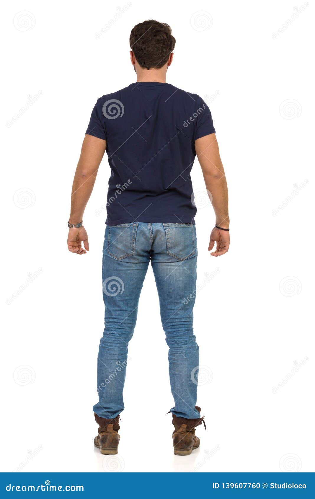 Young Man in Jeans and Blue T-shirt is Standing Relaxed, Rear View ... Young Man in Jeans and Blue T-shirt is Standing Relaxed, Rear View ...