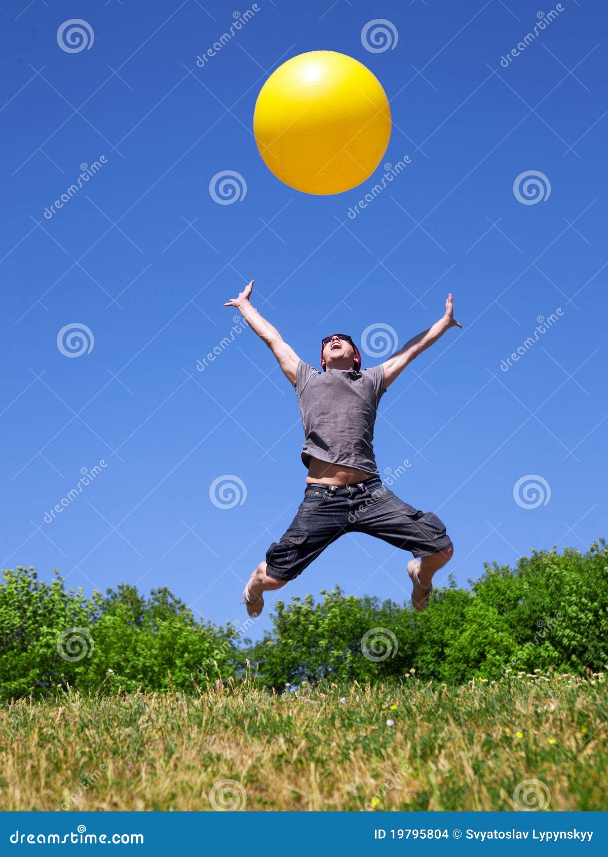 Young Man Jump with Yellow Ball Stock Photo - Image of casual, grass ...