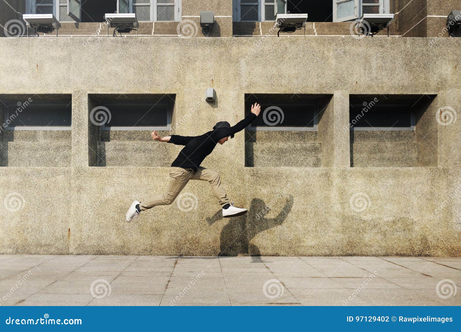 Young Man Jumping in Front of University Campus Building Stock Photo ...