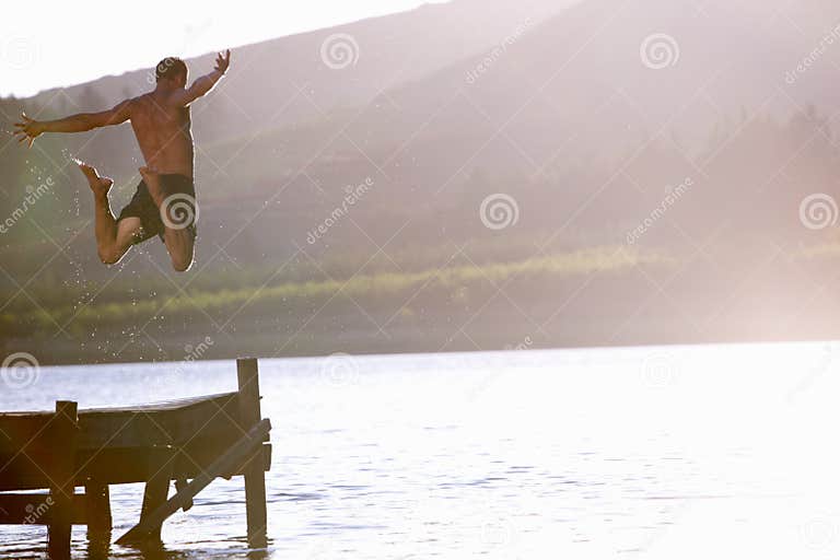 Young Man Jumping into Lake Stock Image - Image of jumping, outside ...
