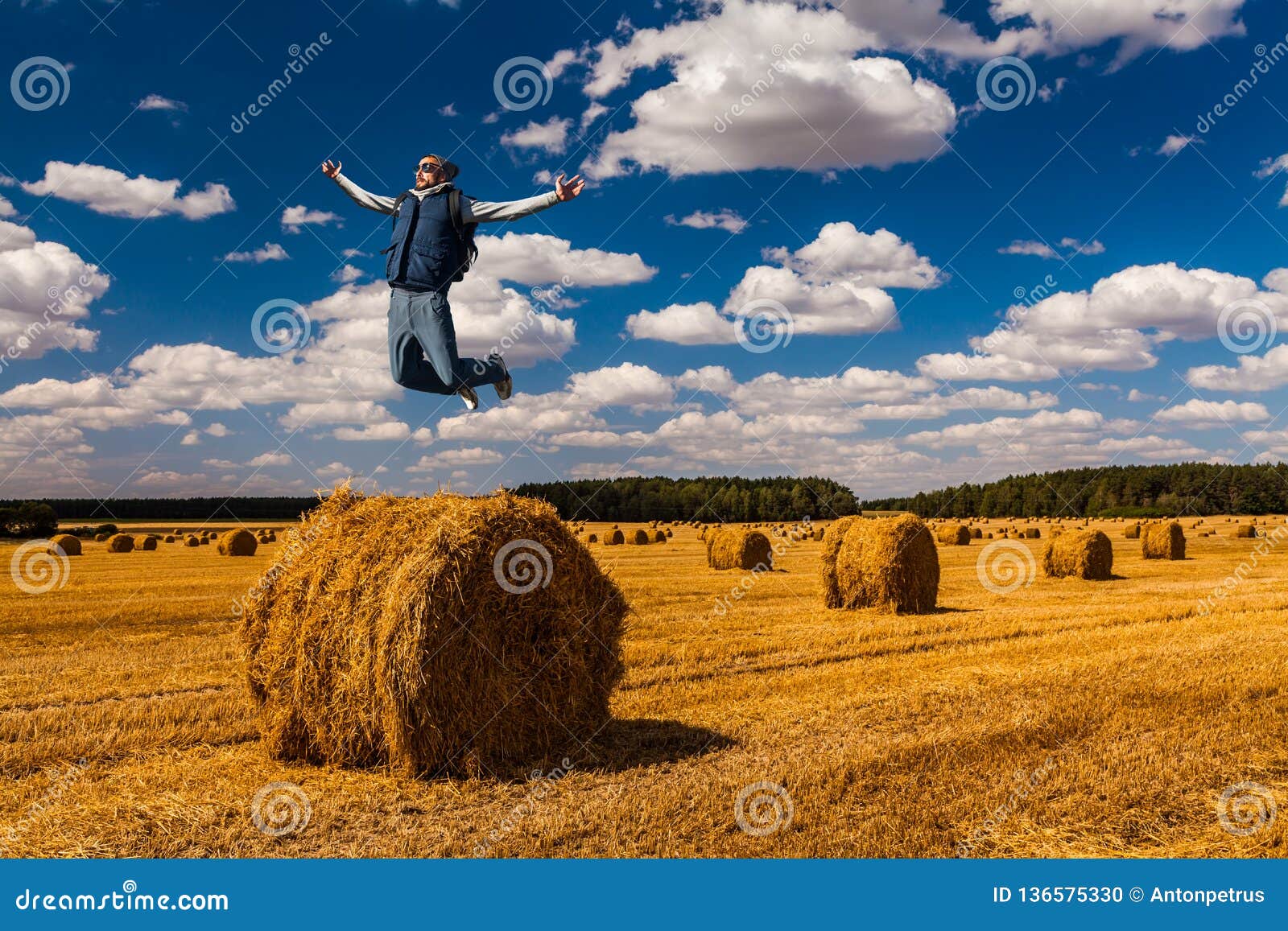 Young Man Jumping Over Haystack on the Summer Day. Stock Photo - Image ...