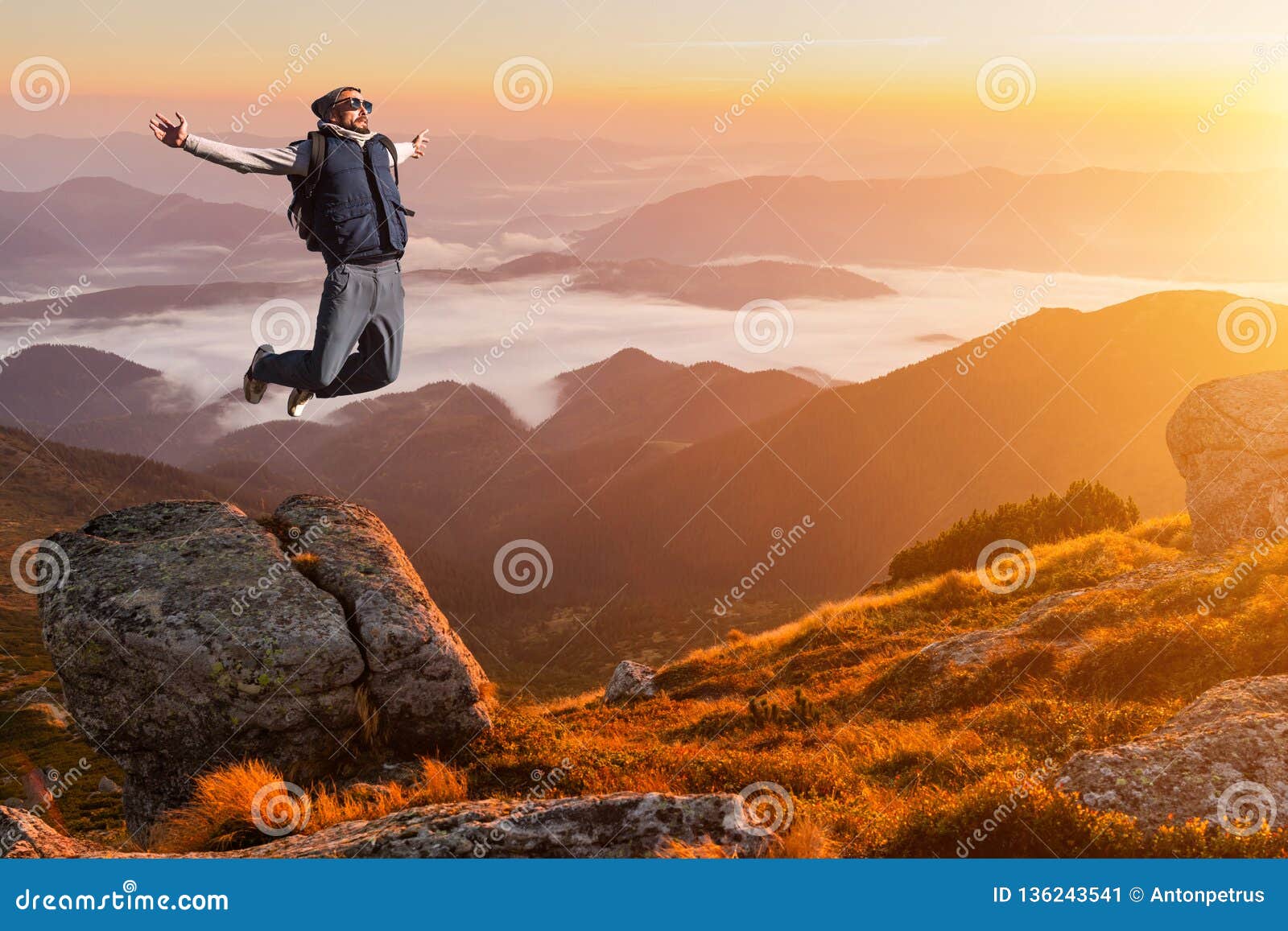 Young Man Jumping on Top of a Mountain Against the Sky Stock Image ...