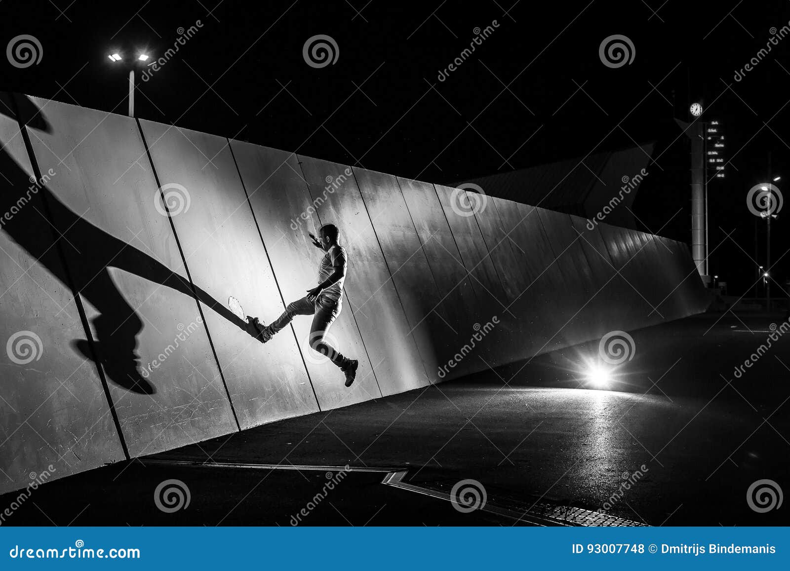 Young Man Is Jumping On The Wall At Night. Huge Shadow On It. Stock ...