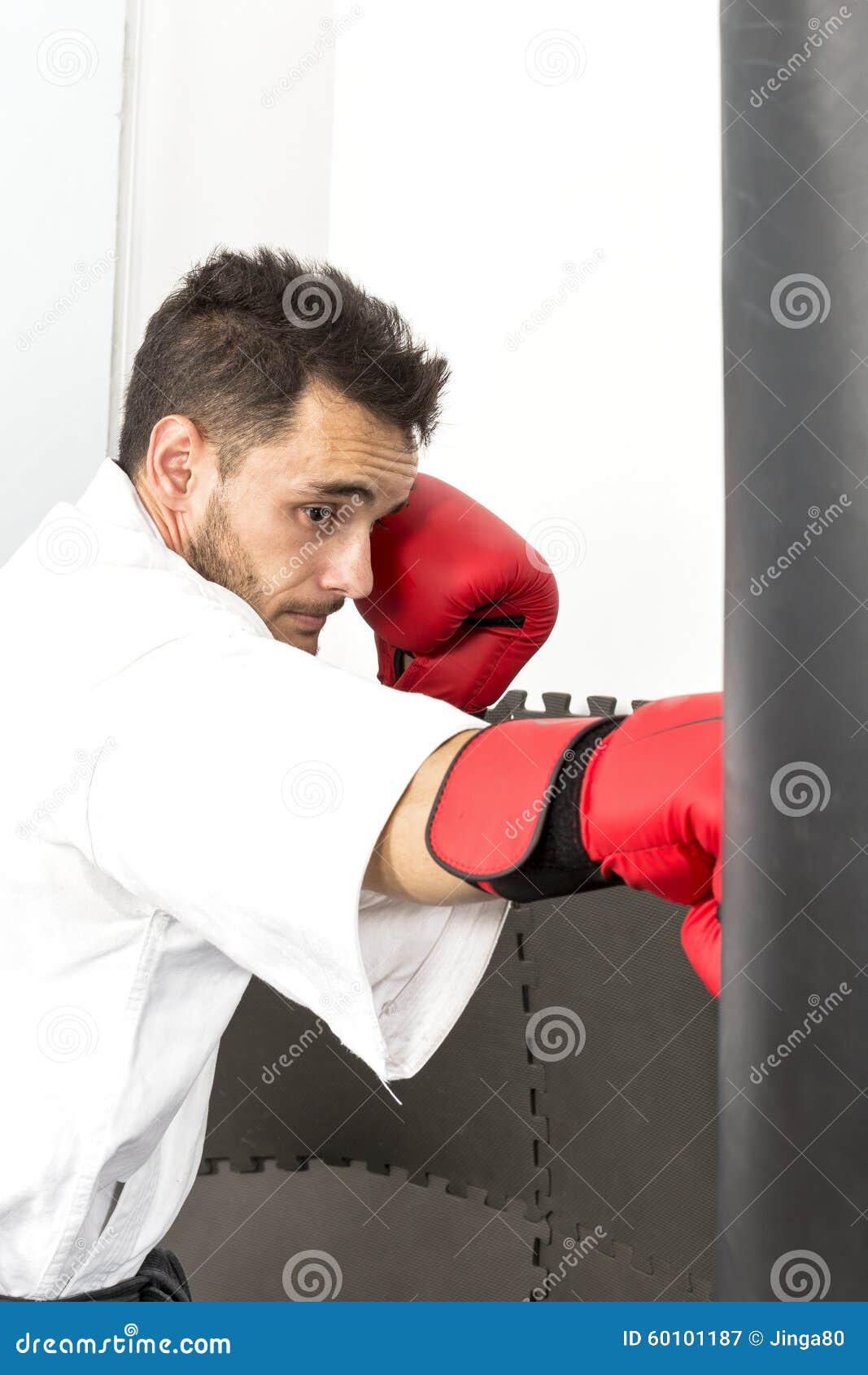 Young Man in Kimono Throwing Punches at a Heavy Punching Stock Image ...