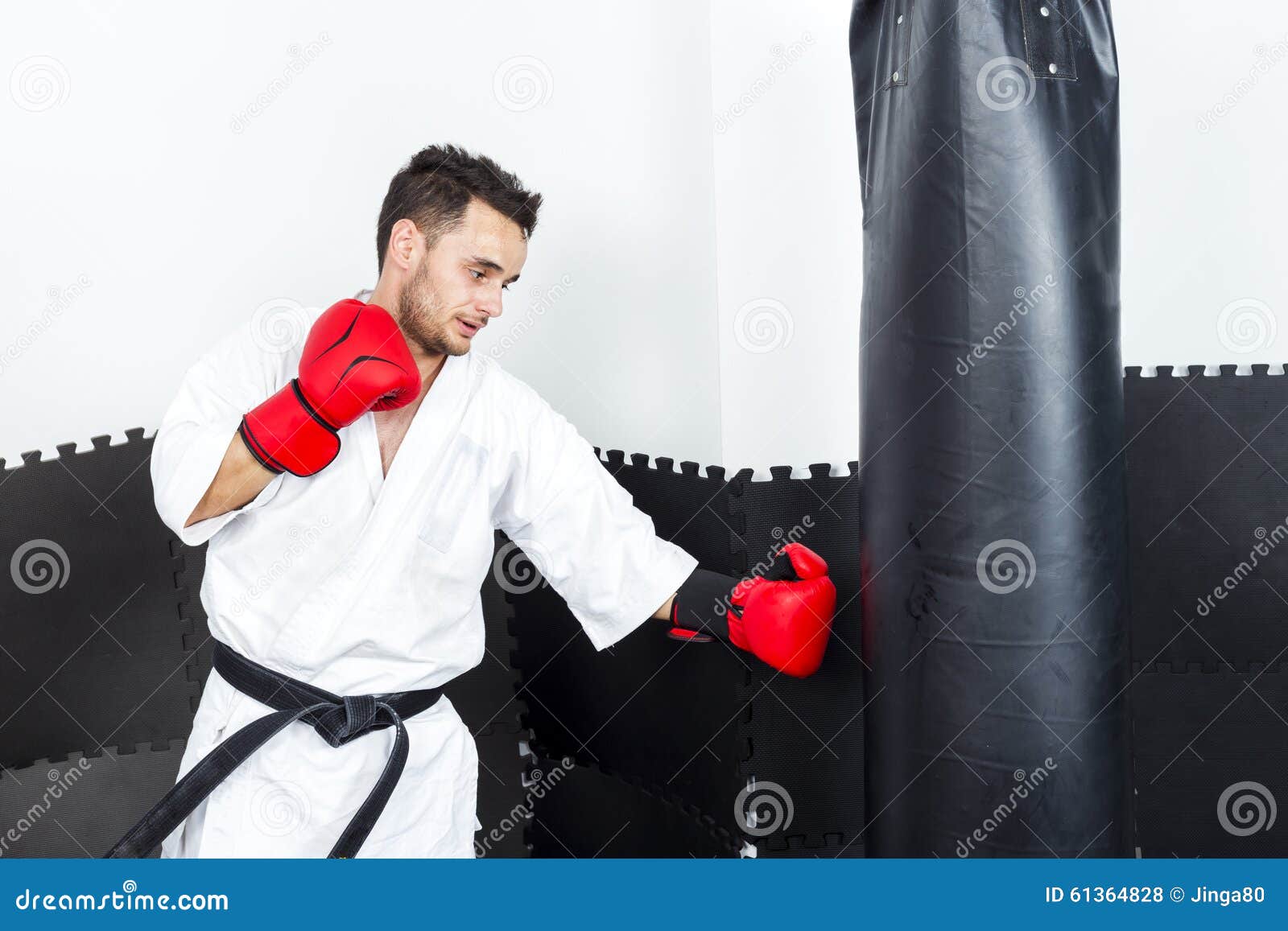 Young Man in Kimono Throwing Punches at a Heavy Punching Bag Stock ...