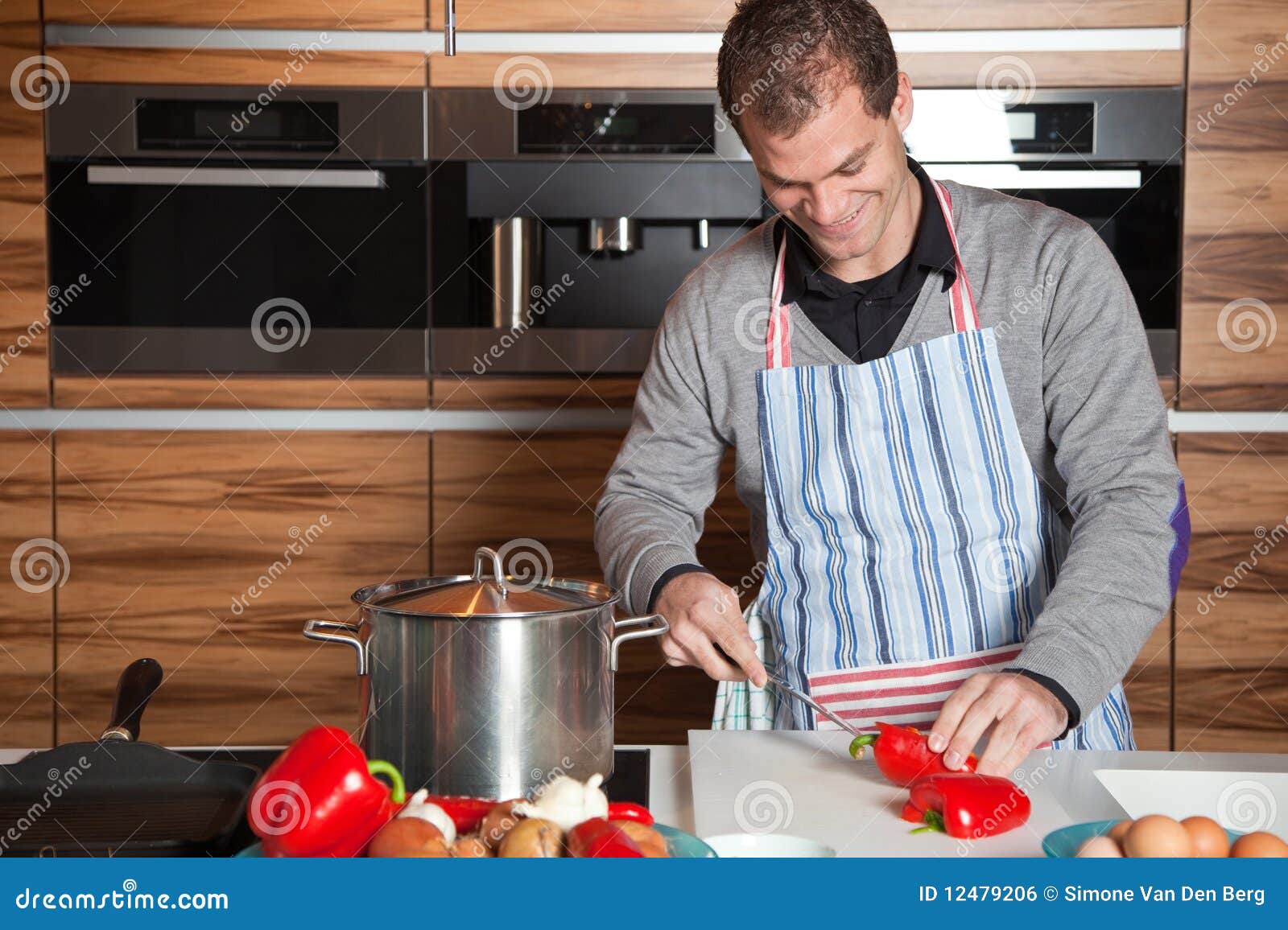 Young man in the kitchen stock photo. Image of cutting - 12479206