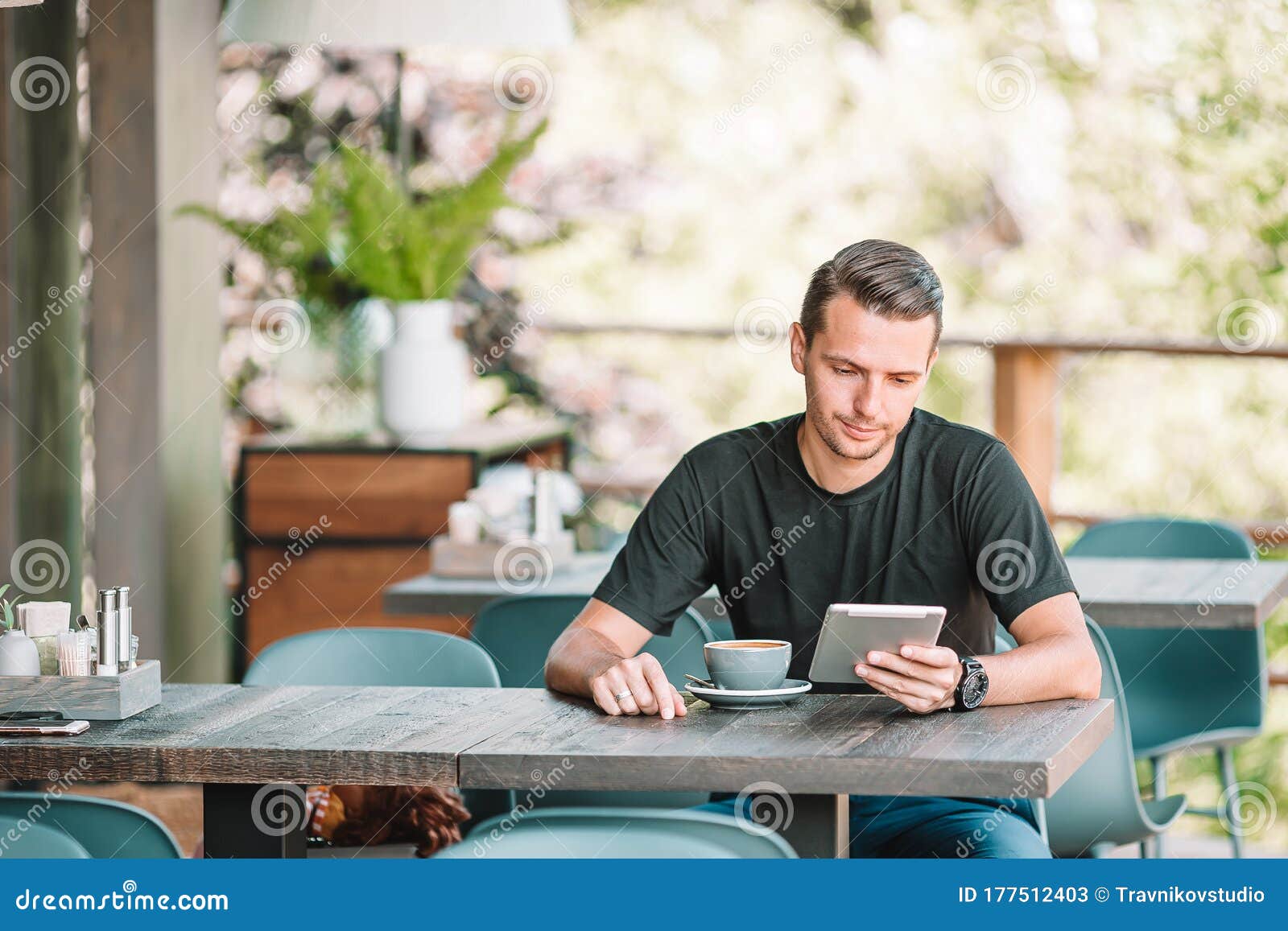 Young Man with Laptop in Outdoor Cafe Drinking Coffee. Stock Image ...