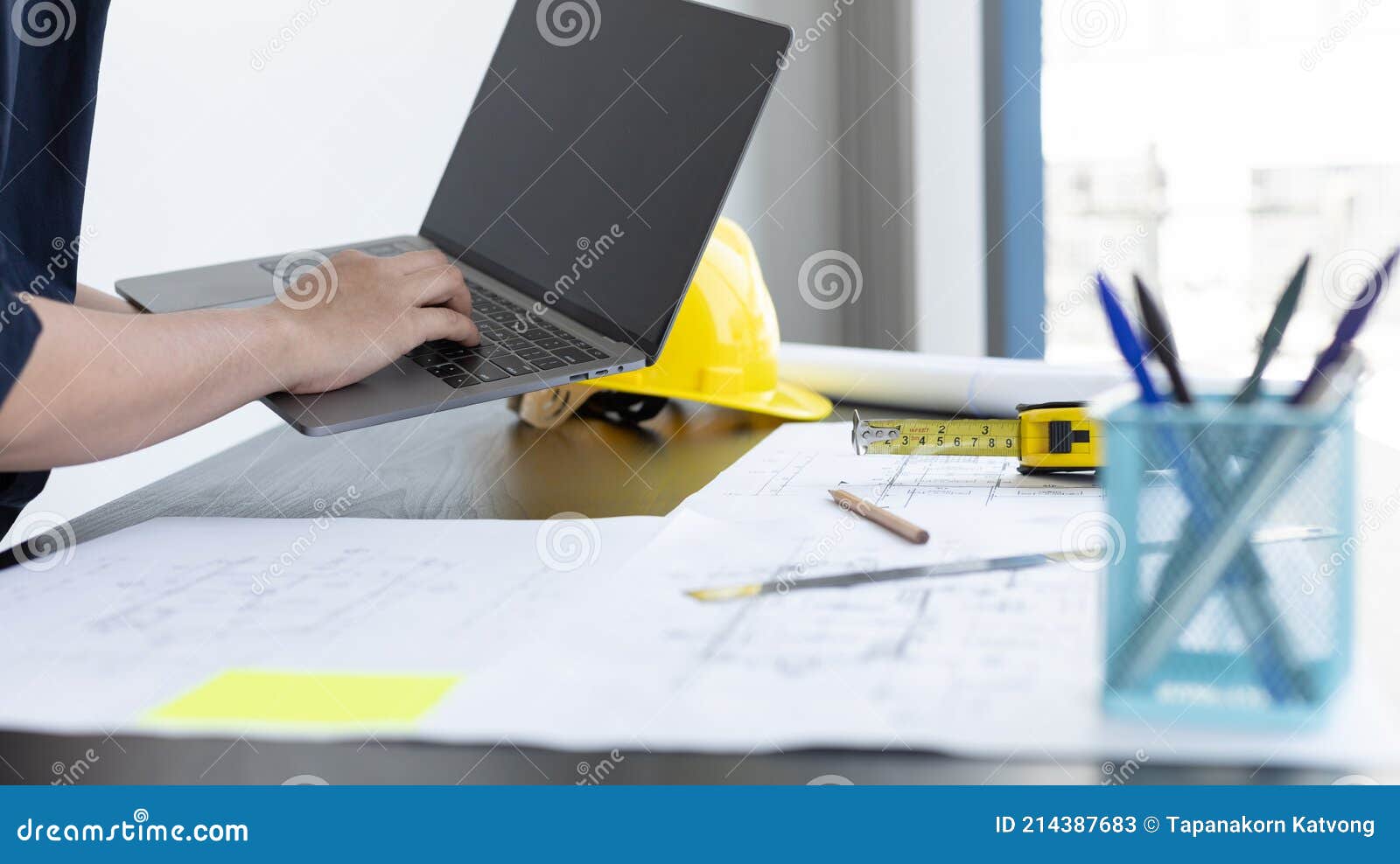 Young Man with a Laptop Plotting a System of Building Structures in ...