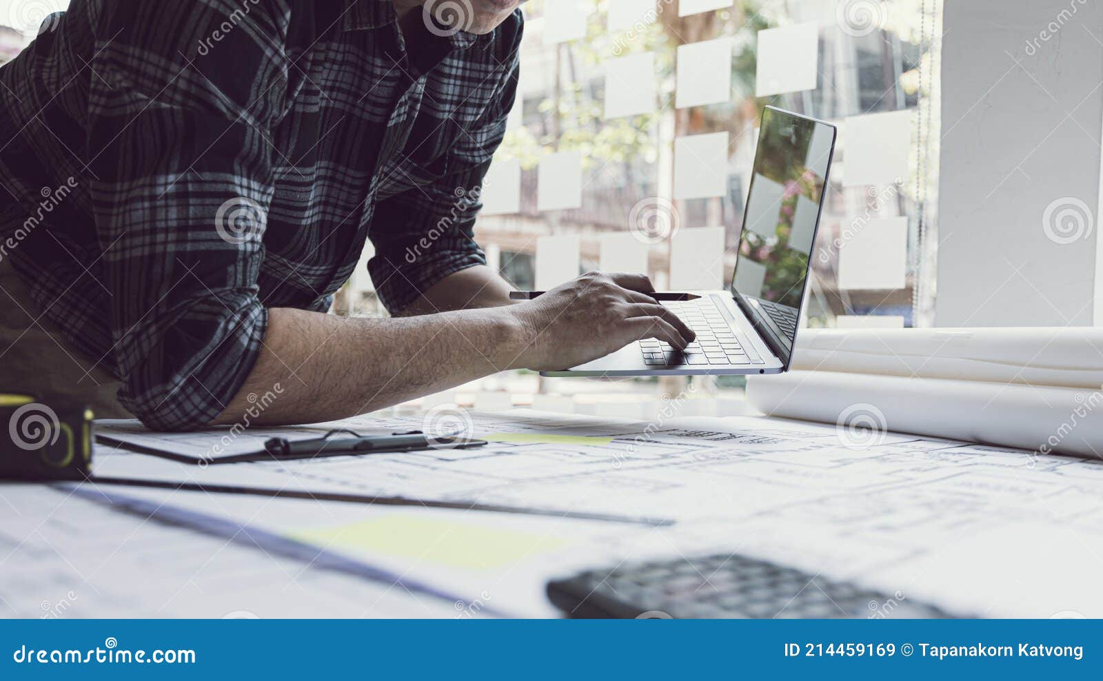 Young Man with a Laptop Plotting a System of Building Structures in ...
