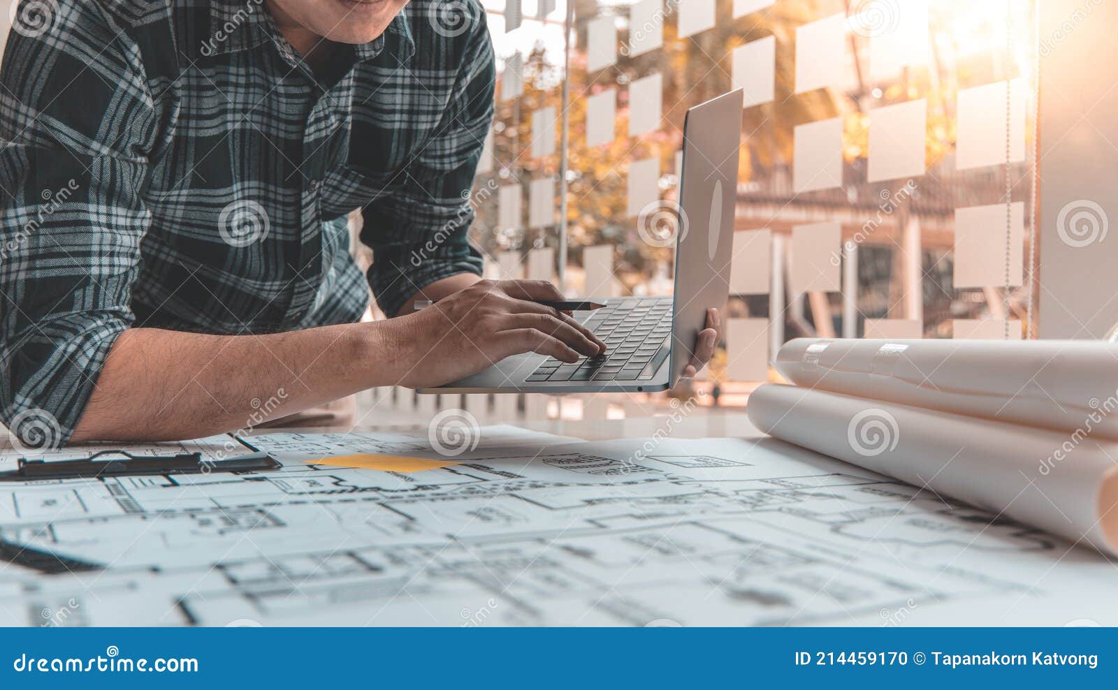 Young Man with a Laptop Plotting a System of Building Structures in ...