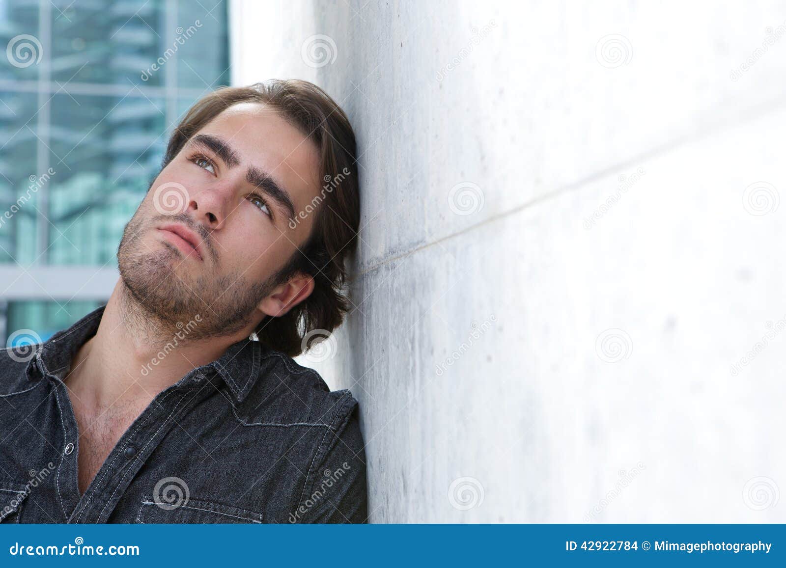 Young Man Leaning Against Wall and Looking Up Stock Photo - Image of ...