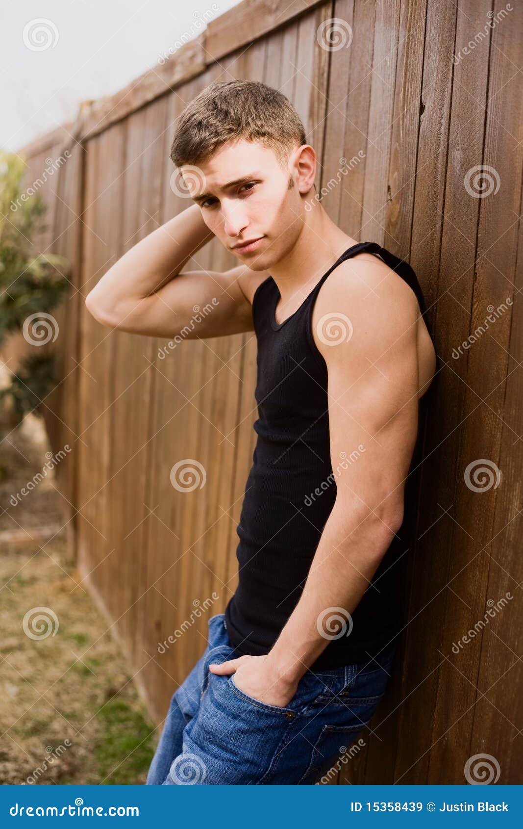 Young man leaning on Fence stock image. Image of hair - 15358439