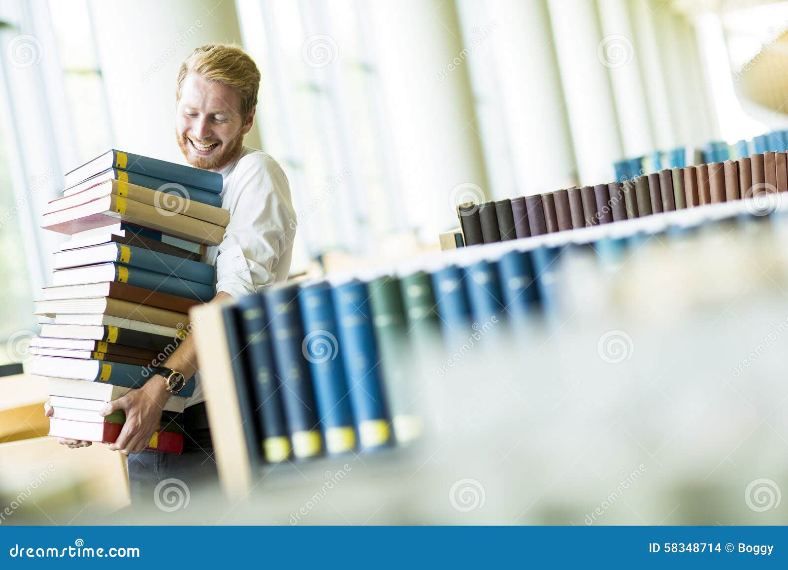 Young man in the library stock photo. Image of carrying - 58348714