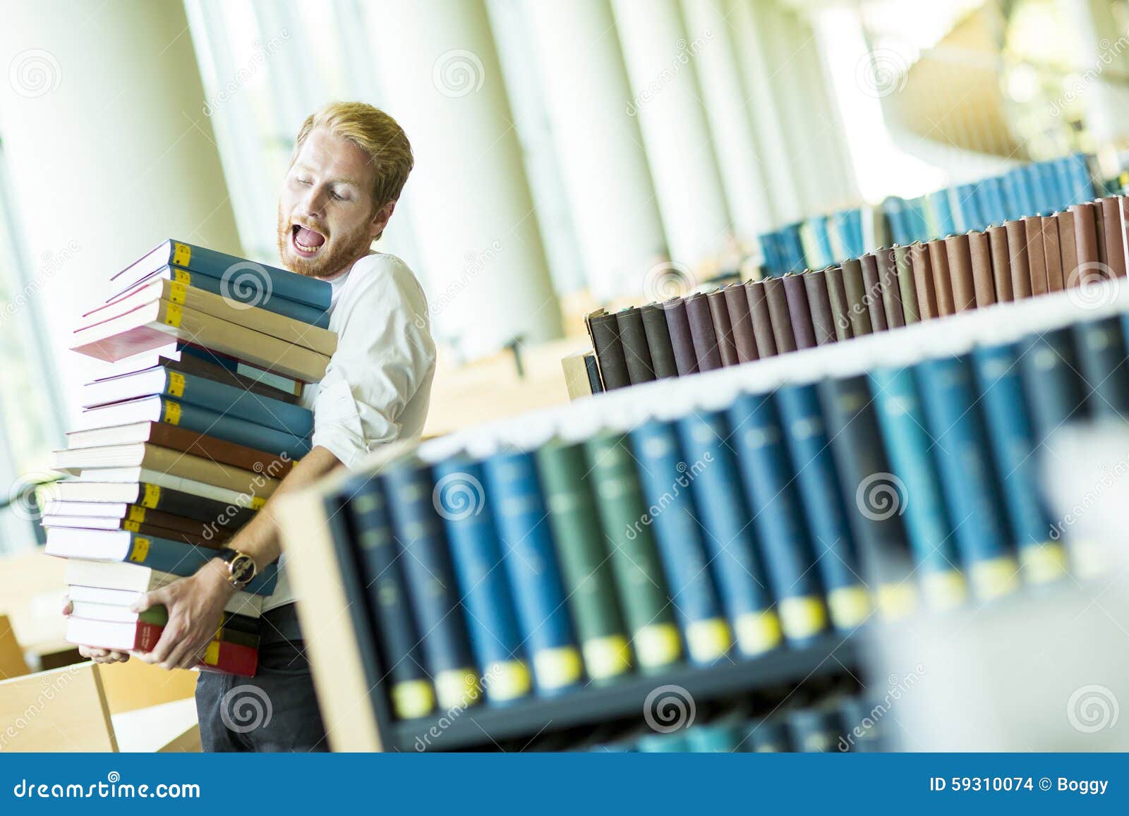 Young man in the library stock photo. Image of education - 59310074