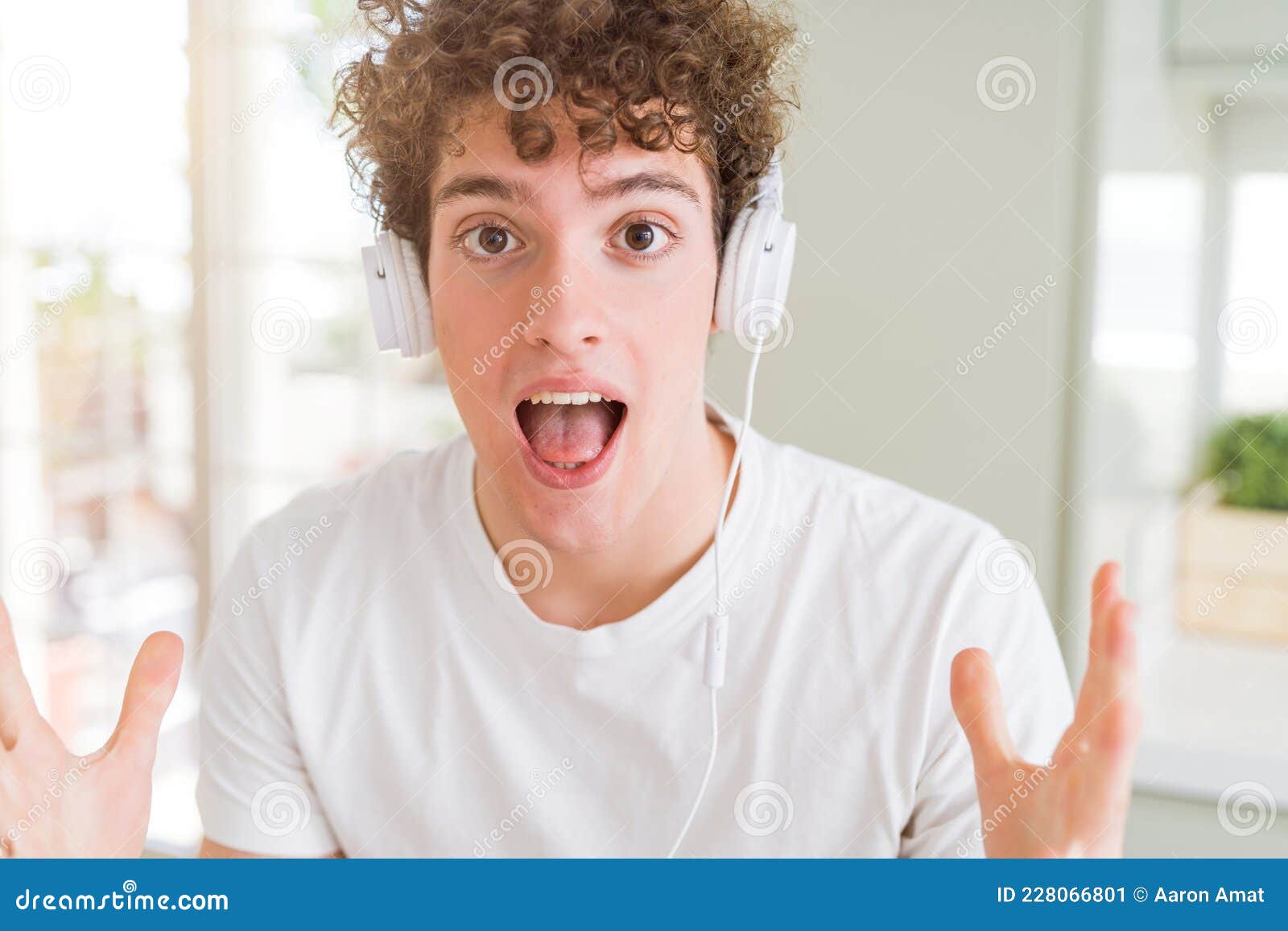 Young Man Listening To Music Wearing Headphones At Homes Celebrating