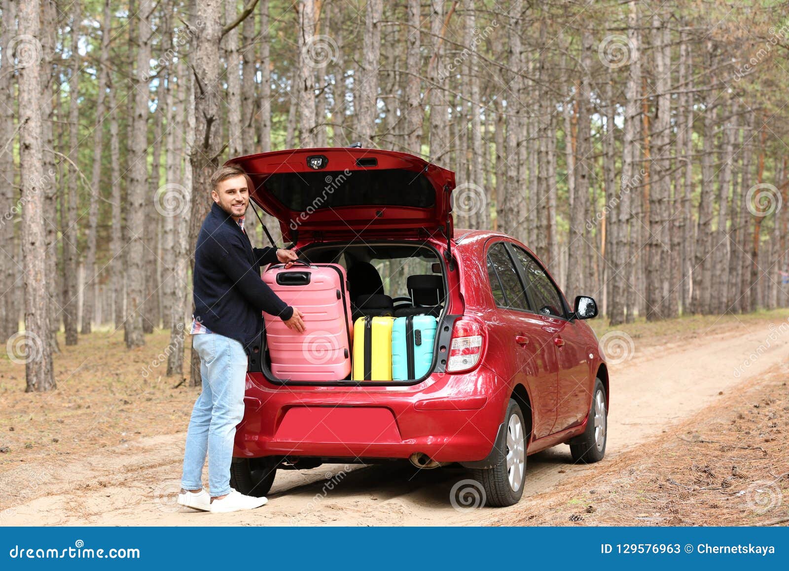 Young Man Loading Suitcase into Car Trunk Stock Image - Image of ...