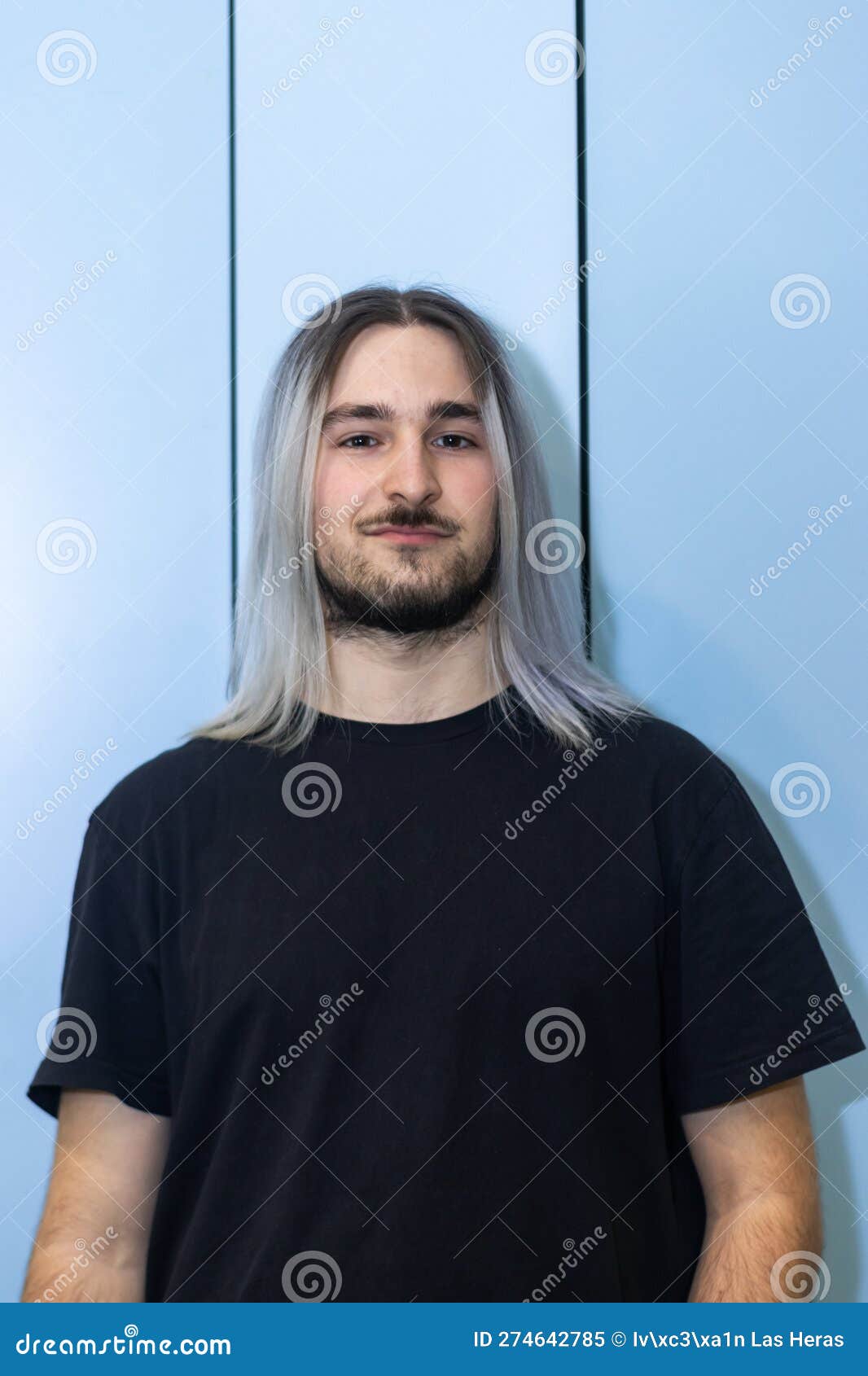 Young Man with Long Grey Hair Posing in Front of a Blue Wall Stock ...
