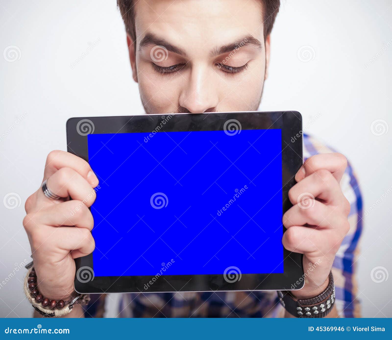 Young Man Looking Down while Holding a Tablet Pad Computer Stock Photo ...
