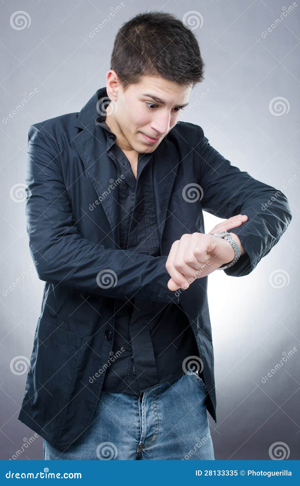 Young Man Looking at His Watch Stock Image - Image of gray, jeans: 28133335