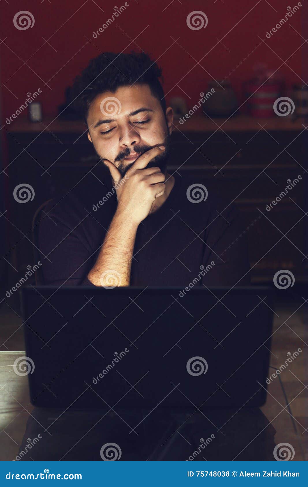 Young Man Looking at Laptop and Thinking in Dark Room Stock Photo ...
