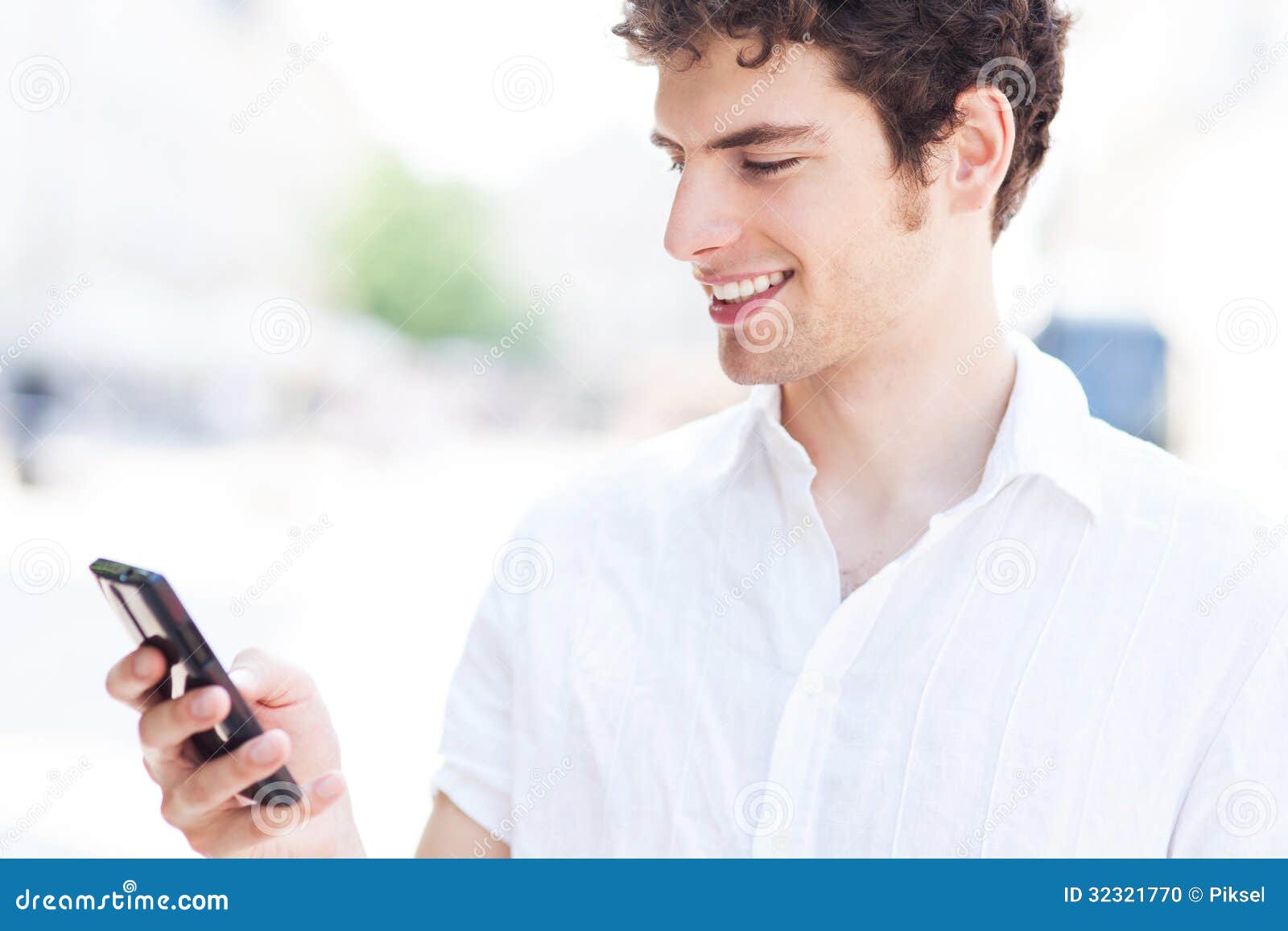 Young Man Looking at Mobile Phone Stock Photo - Image of holding ...